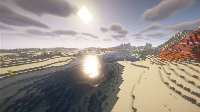 A desert coast in Minecraft, with the sun shining down on a warm ocean made more vibrant thanks to BSL Shaders.